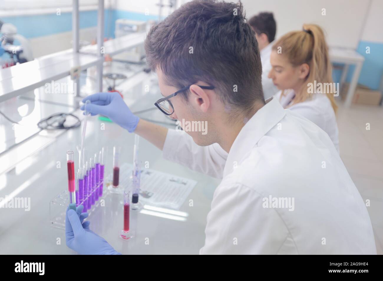 Group of young Laboratory scientists working at lab with test tubes and ...