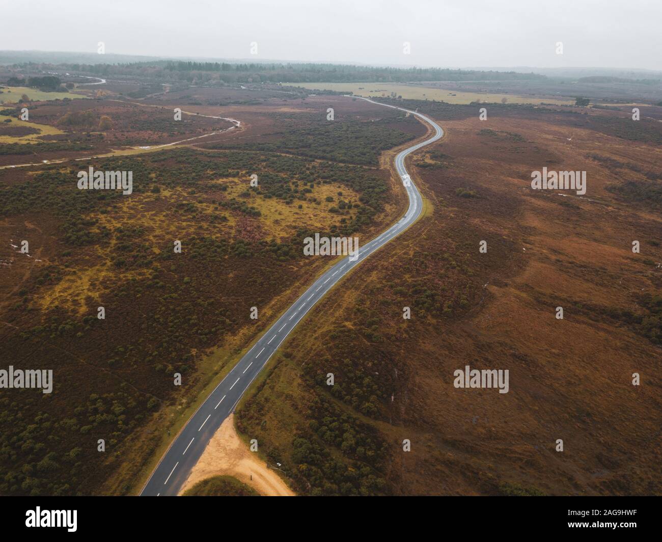 Aerial shot of a road in the middle of a green landscape in the New ...
