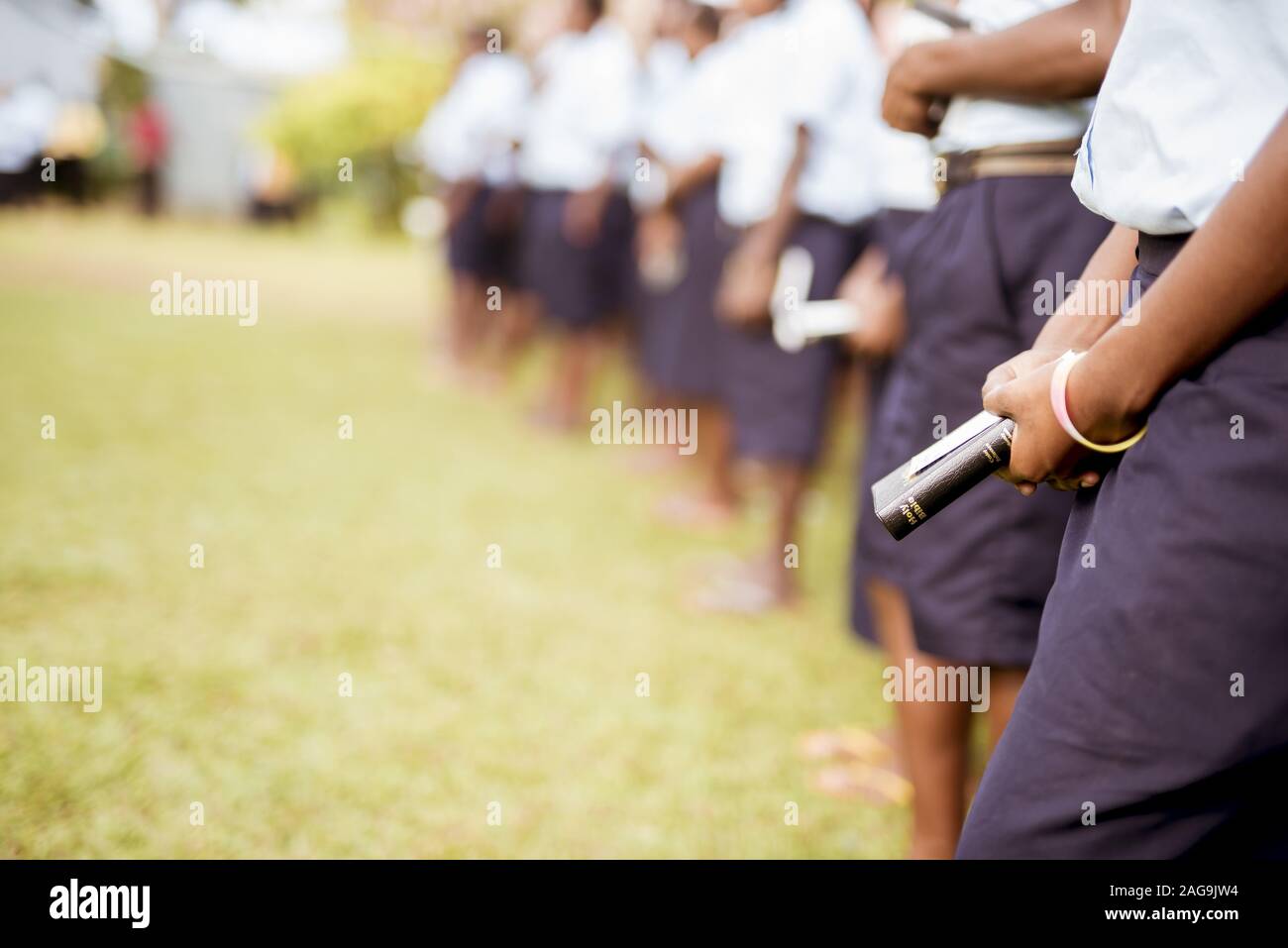 Shallow focus shot of a person wearing a uniform and holding the bible ...