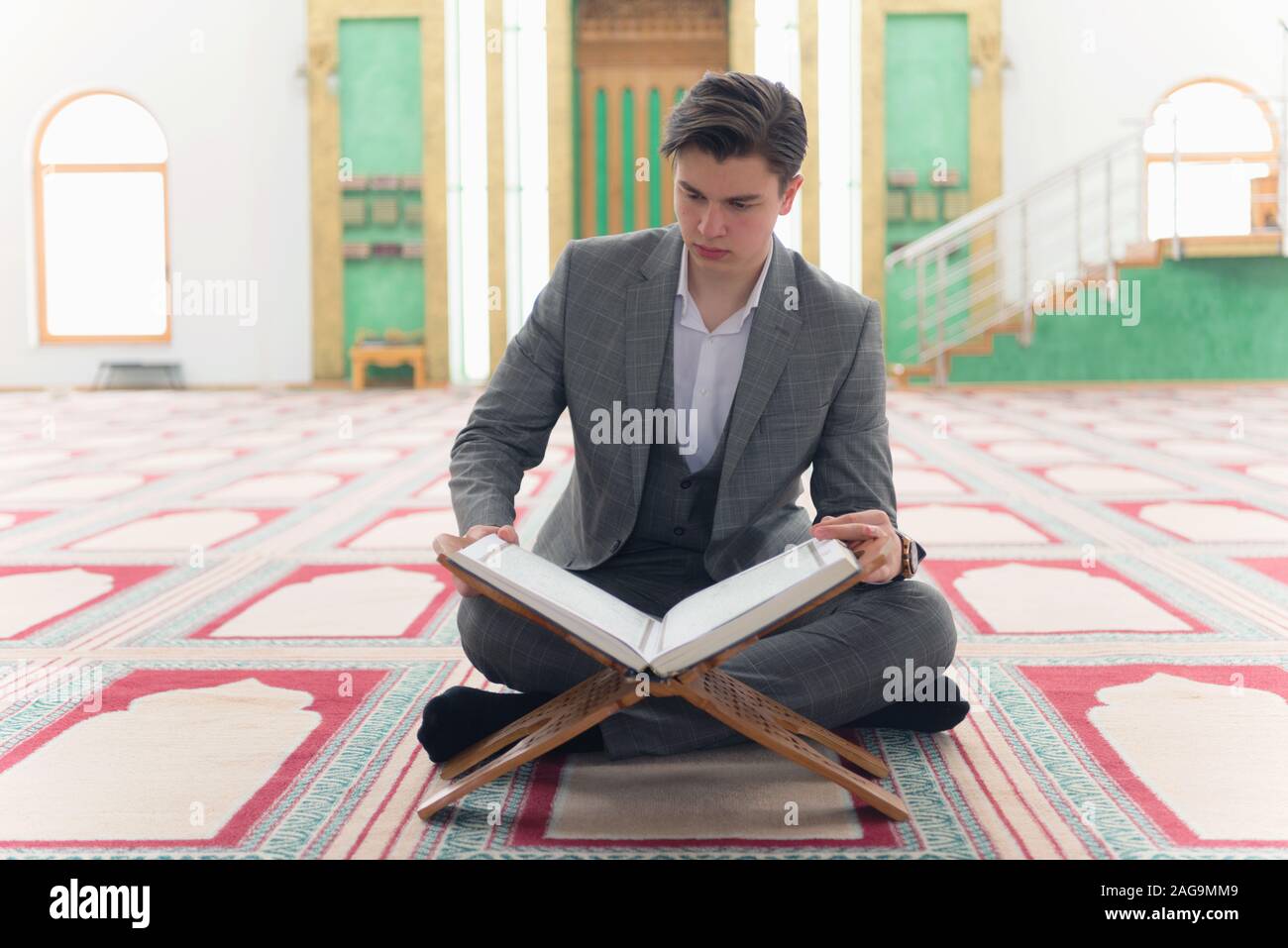 Religious muslim man praying inside the mosque and reading holy book ...