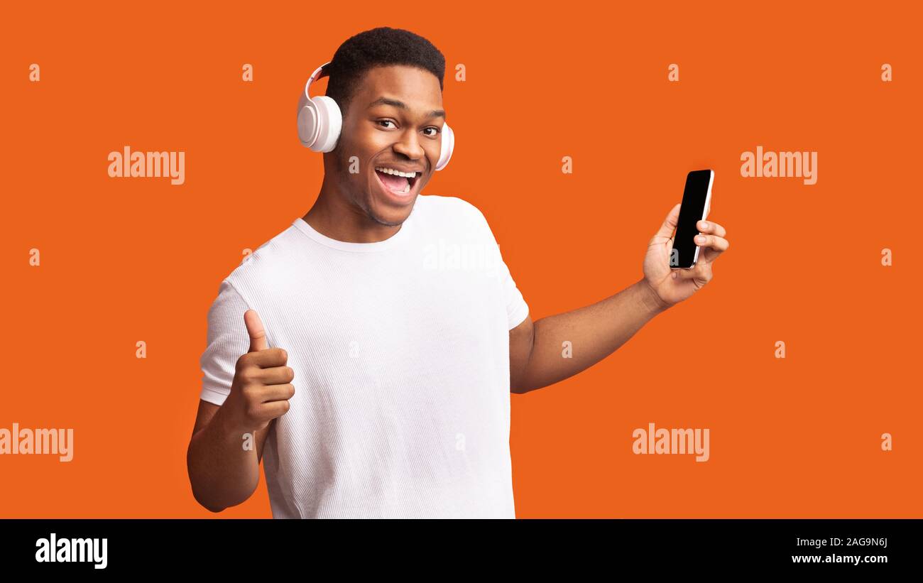 Portrait of smiling afro guy enjoying music Stock Photo - Alamy
