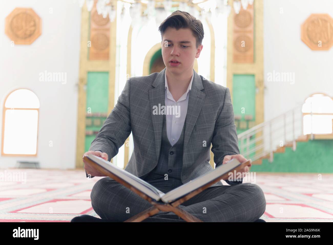 Religious young hafiz muslim man praying inside the mosque and reading ...