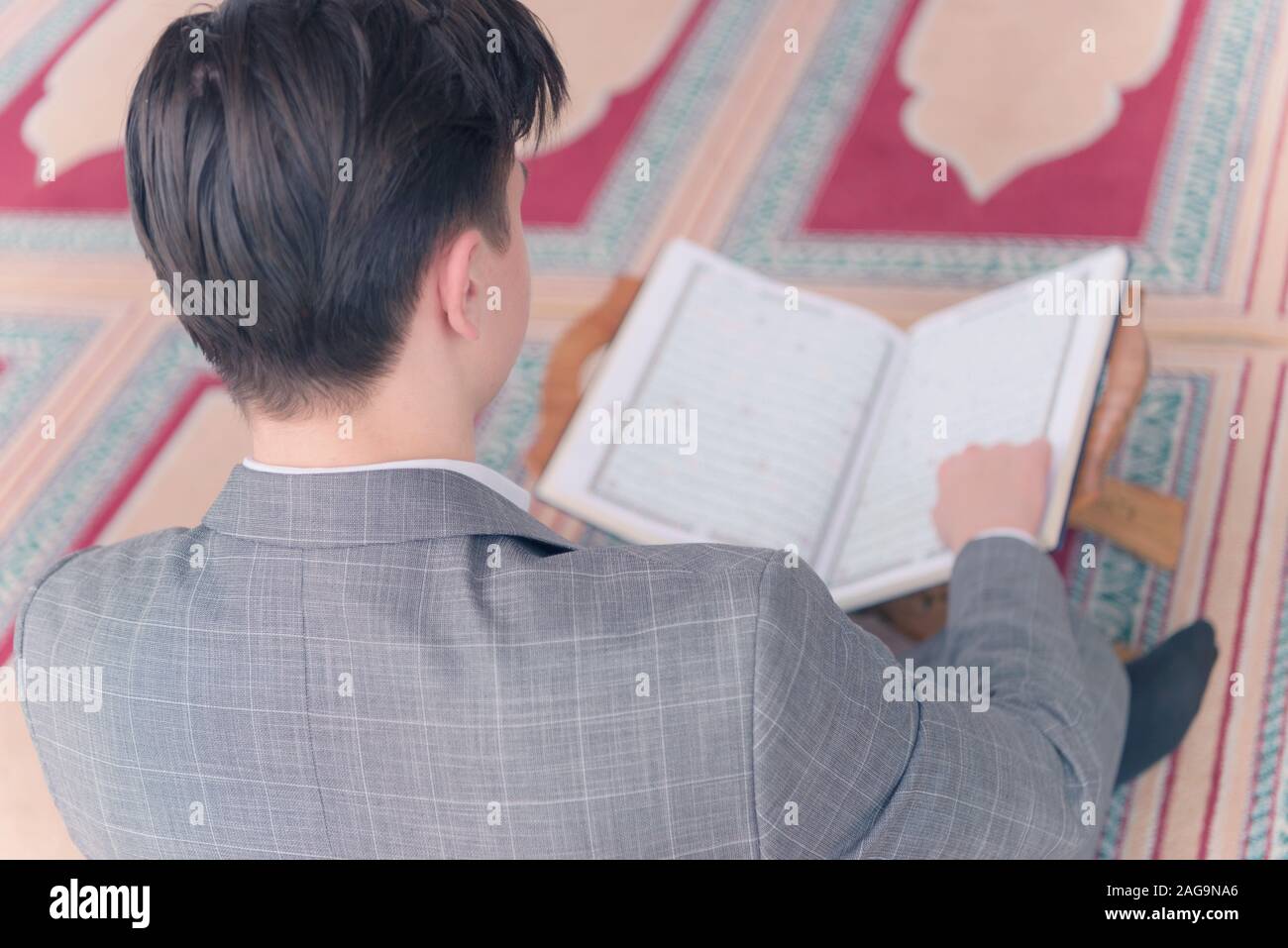 Religious young hafiz muslim man praying inside the mosque and reading ...