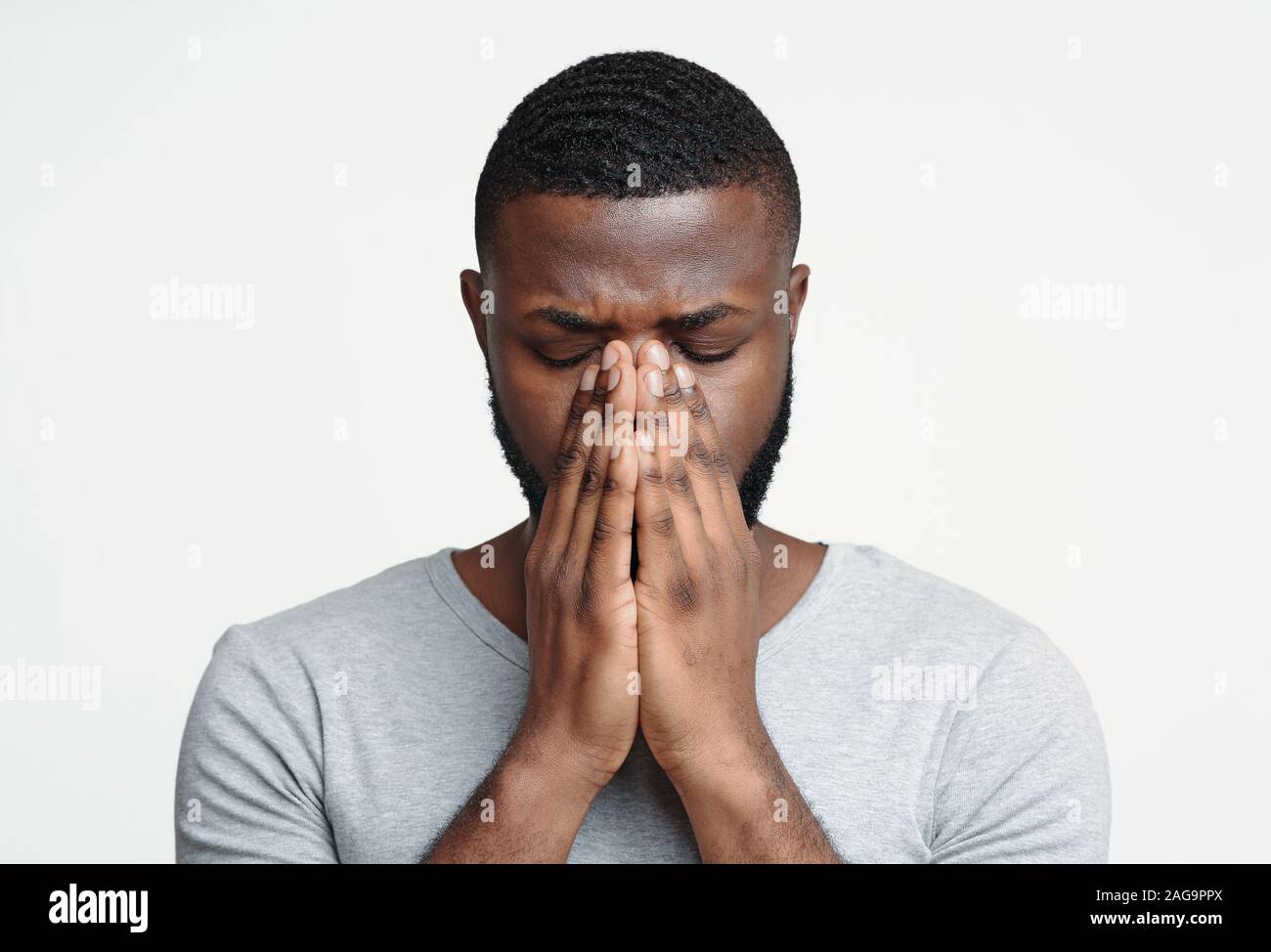 Sad black man holding his nose because sinus pain Stock Photo - Alamy