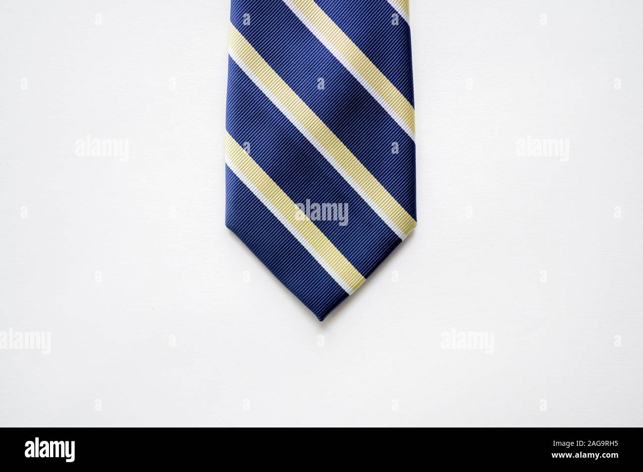 Overhead shot of a blue and yellow striped tie on a white surface Stock ...