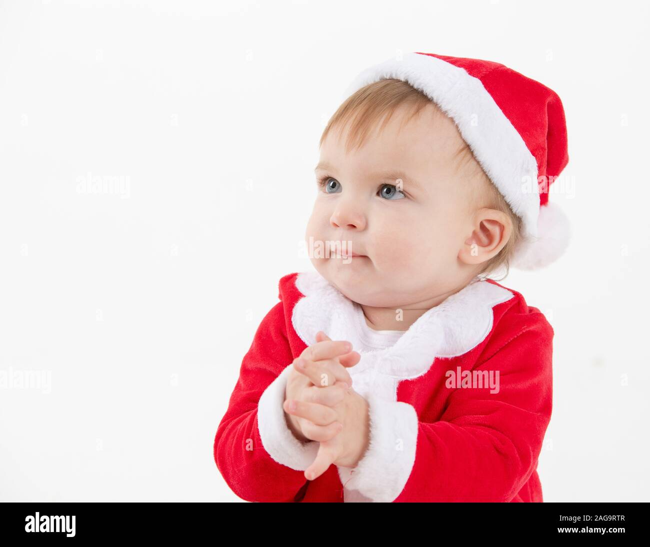 Stock studio photo with a white background of a baby dressed as Santa ...
