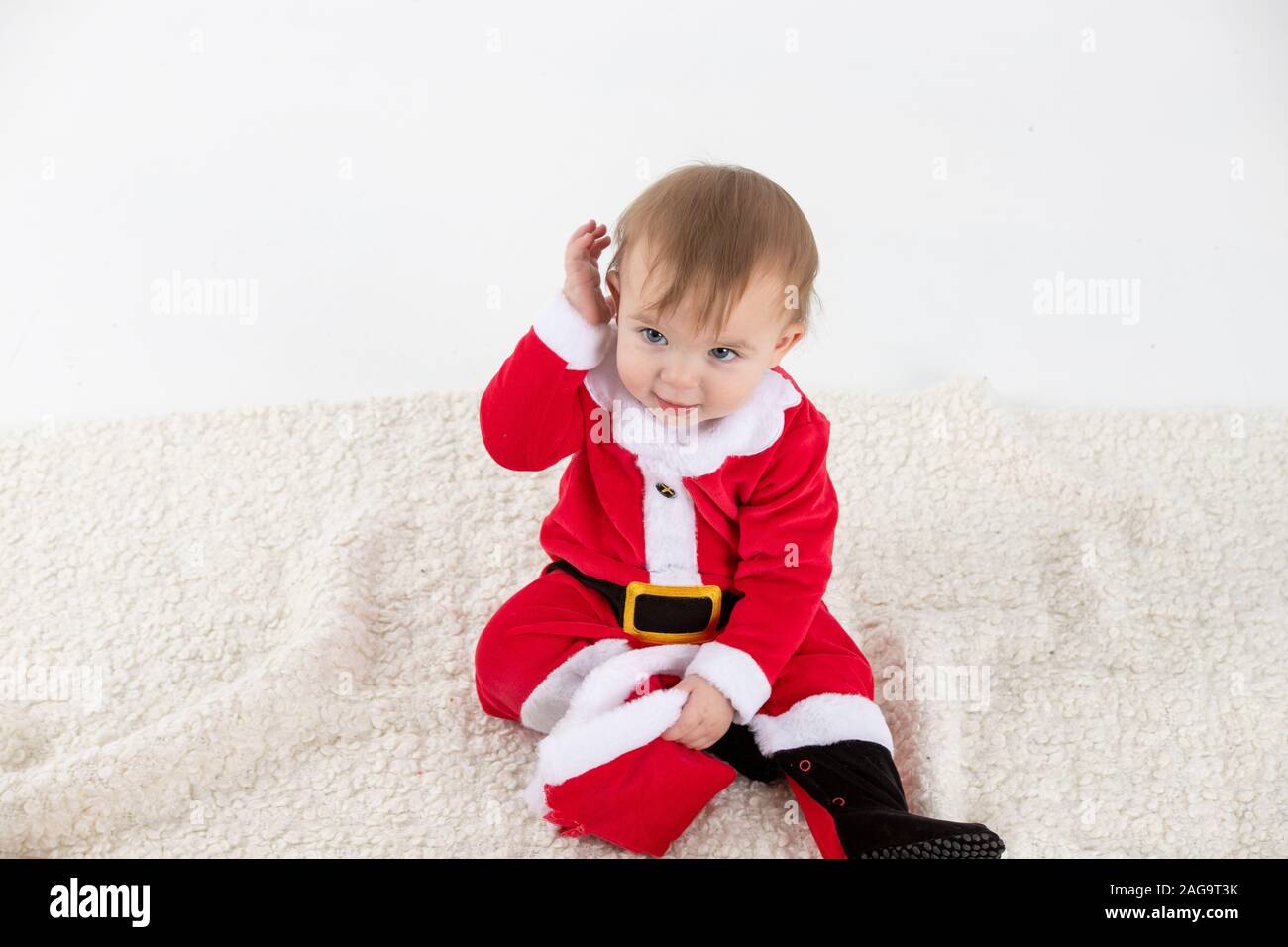 Stock studio photo with white background of a baby disguised as santa ...