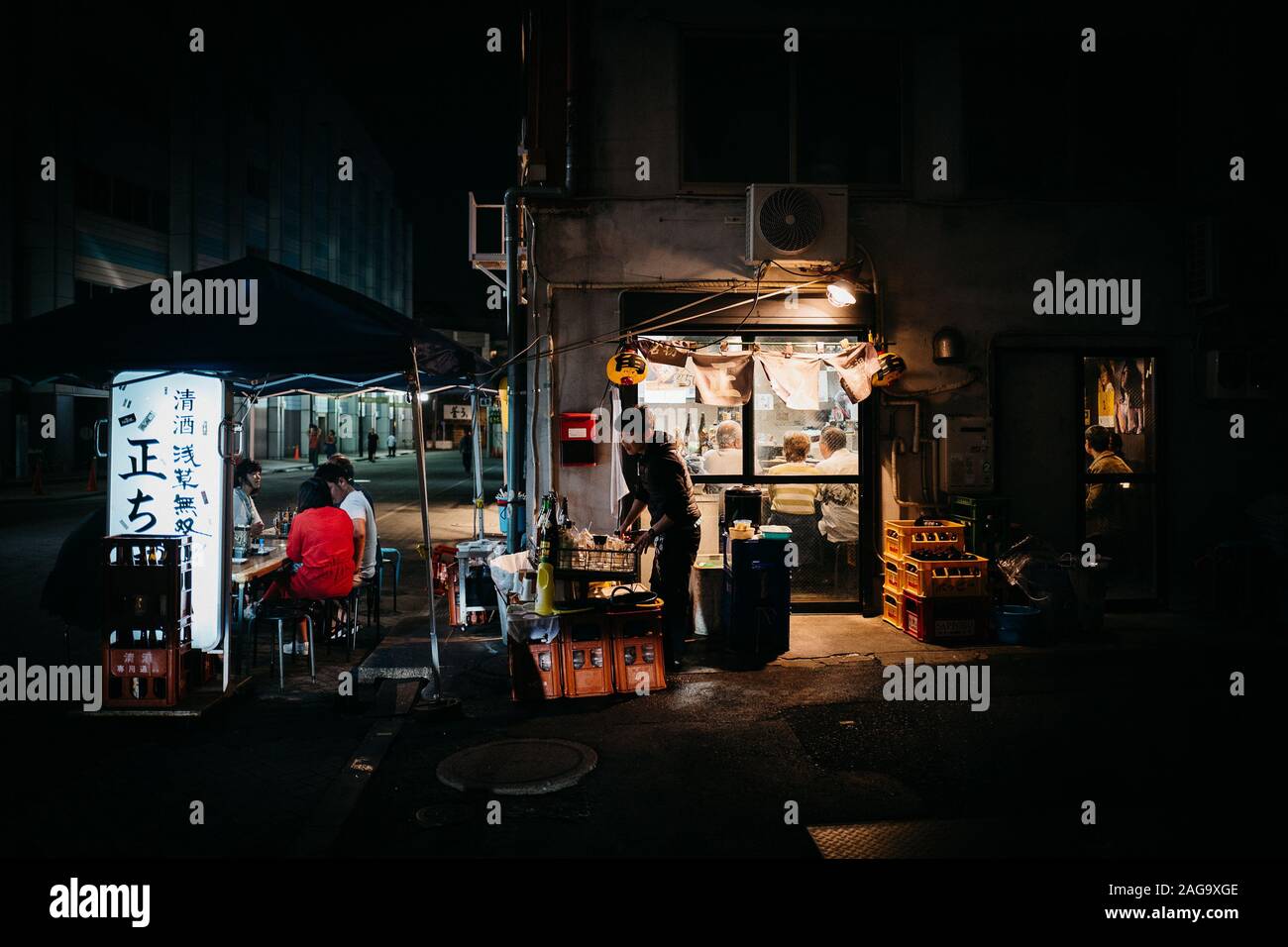 TOKYO, JAPAN - Apr 30, 2018: Diners sit outside small restaurant in a ...