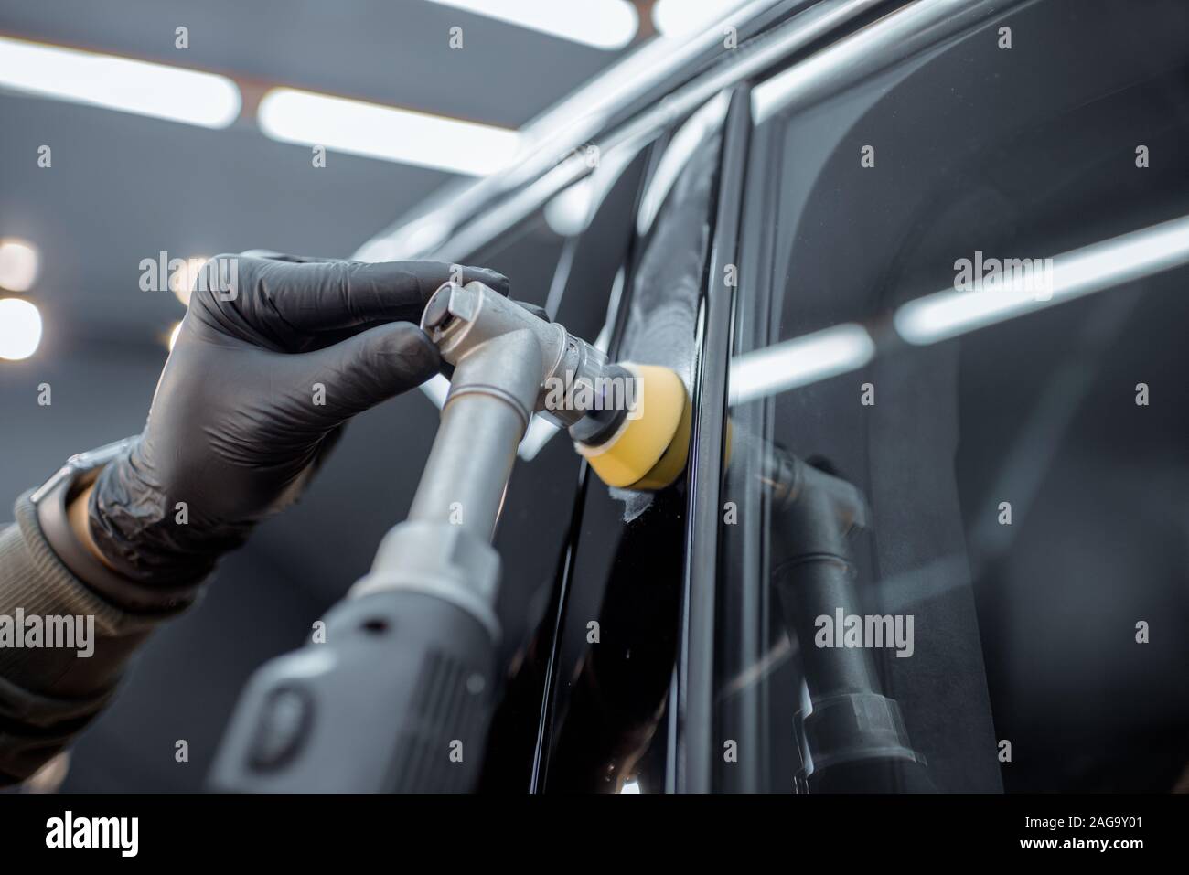 Car service worker polishing vehicle body with special wax from ...