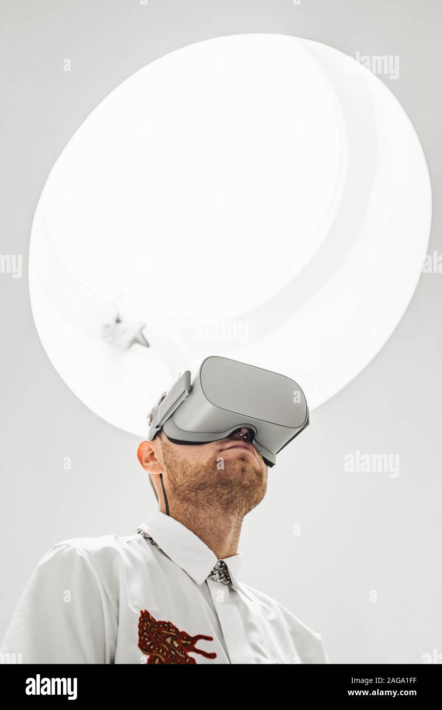 Vertical low angle shot of a person wearing virtual reality goggles ...