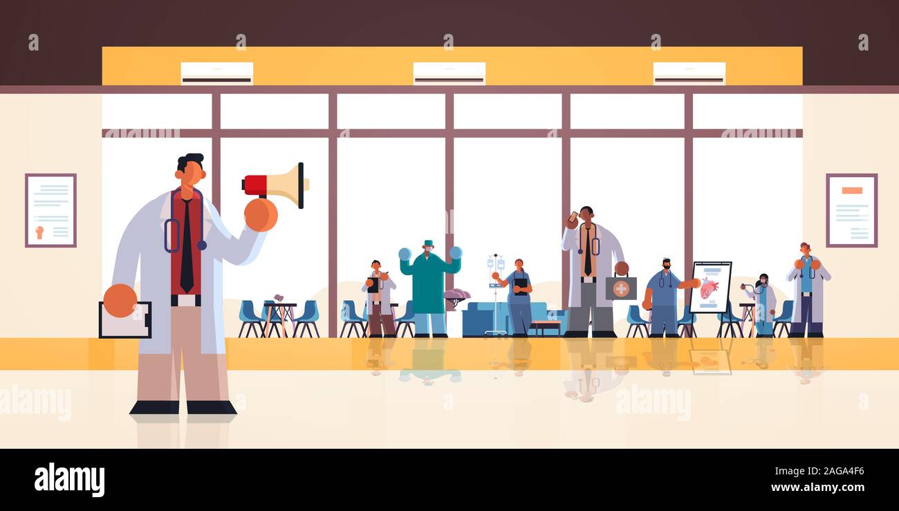 male doctor using loudspeaker making announcement for mix race hospital ...