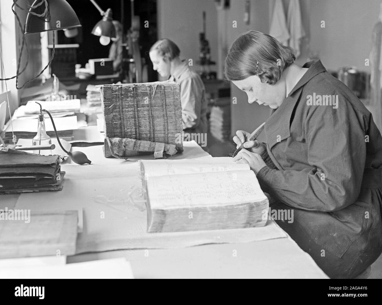 Female bookbinders working conservation work on books bookbindery ...