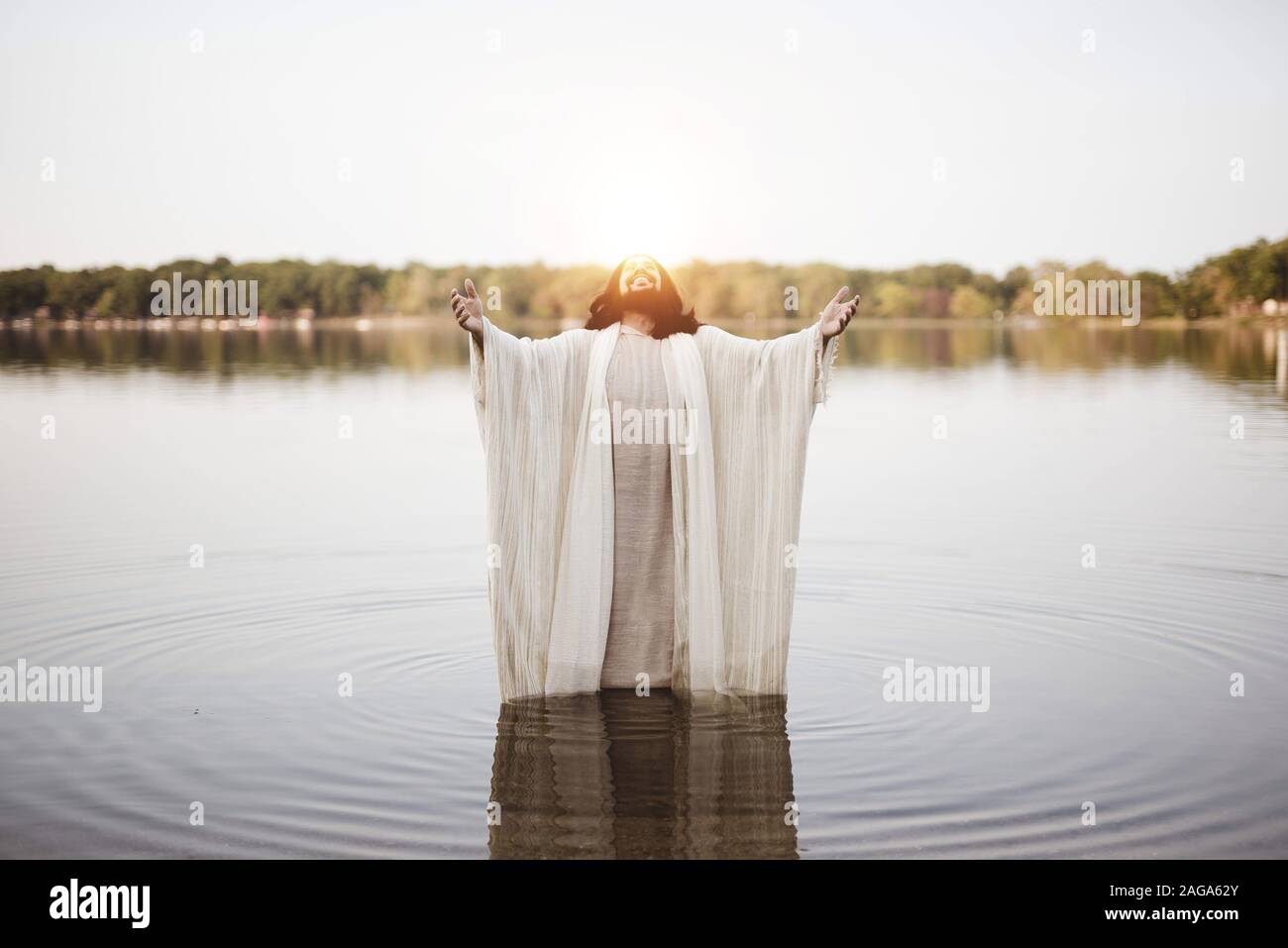 Jesus Christ standing in the water with his hands and head towards the ...