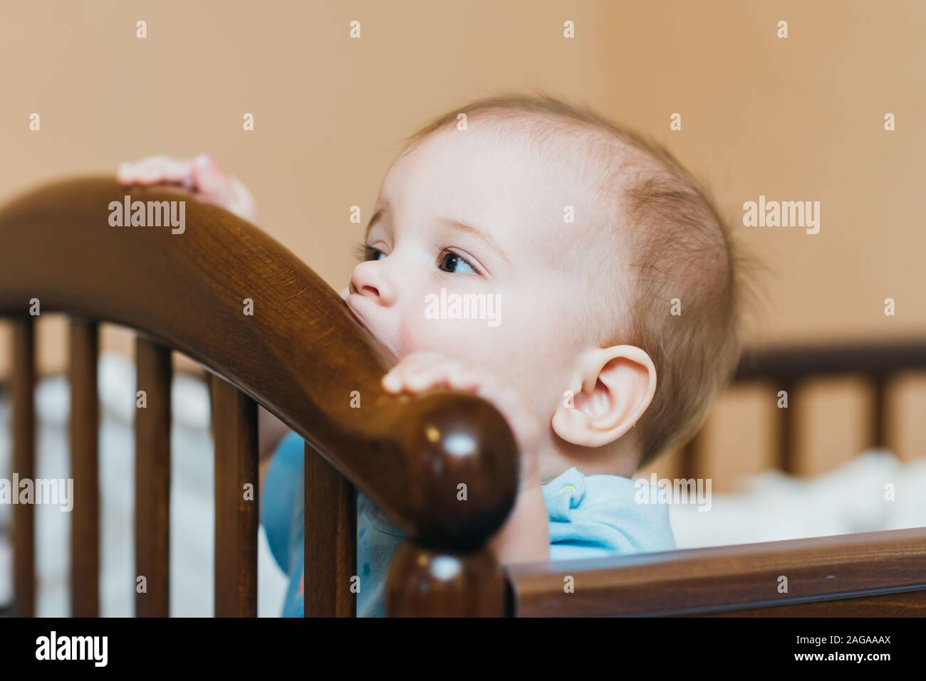 little boy chewing on her bed at home Stock Photo - Alamy