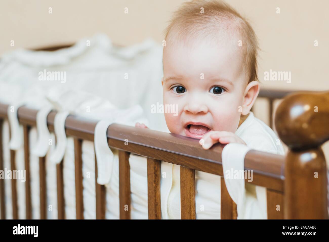 little boy chewing on her bed at home Stock Photo - Alamy