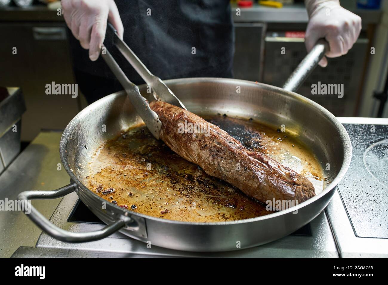 Cooking beef in a restaurant. steak and chef. closeup piece of roast ...