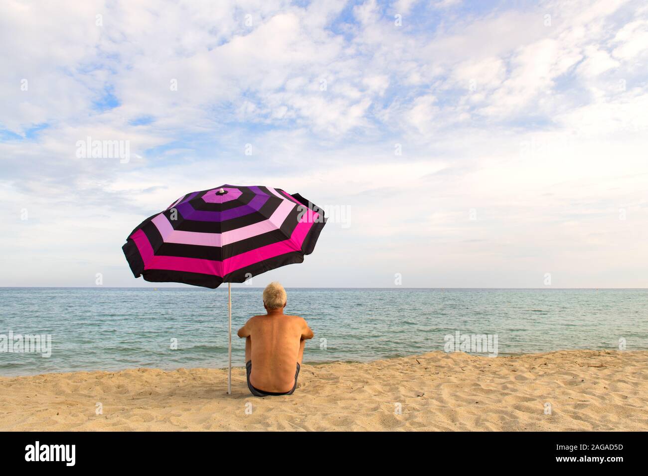 man on vacation with shade under umbrella at the beach Stock Photo - Alamy