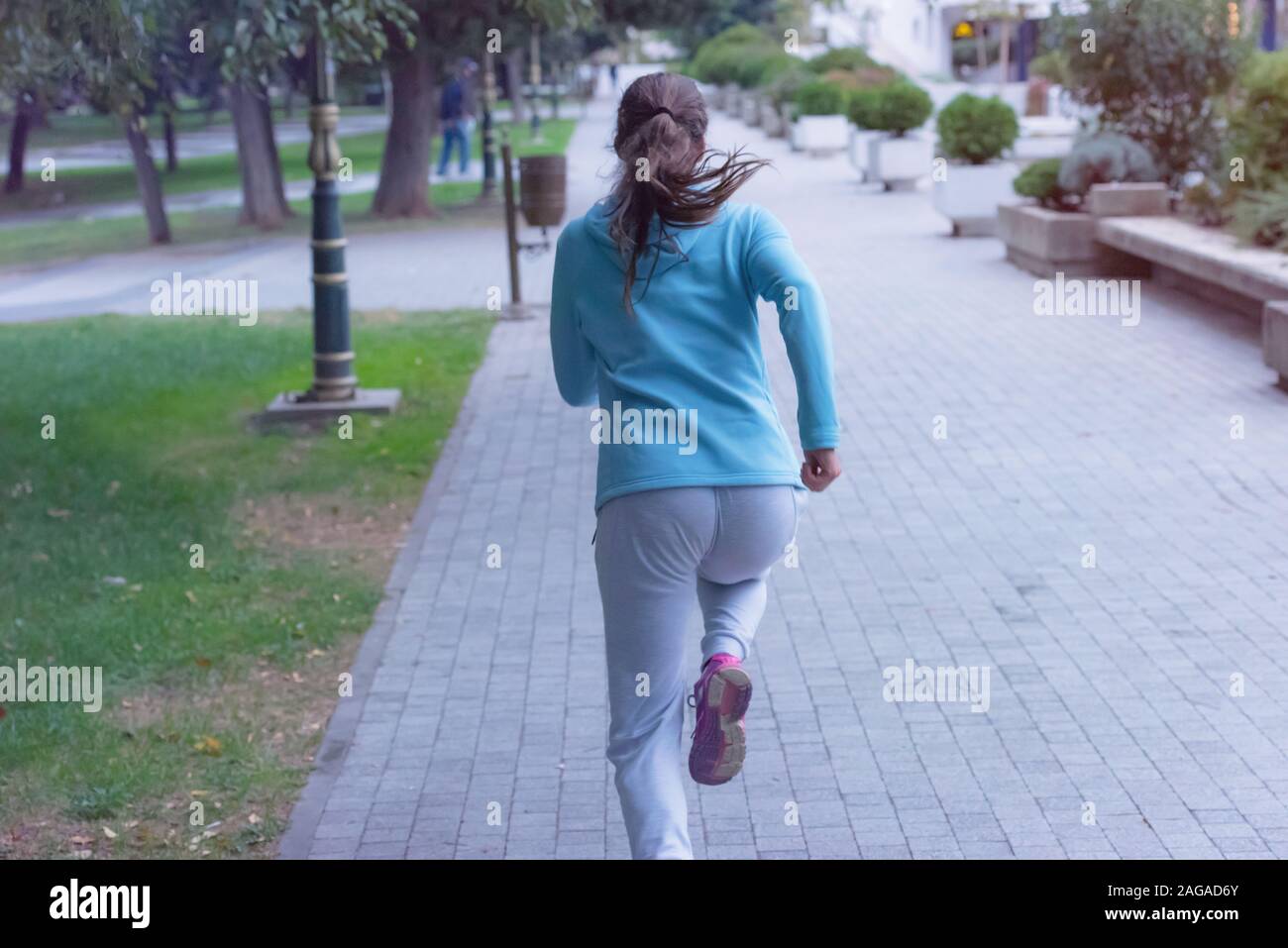 Running woman. Female fitness model training outside in the city Stock ...