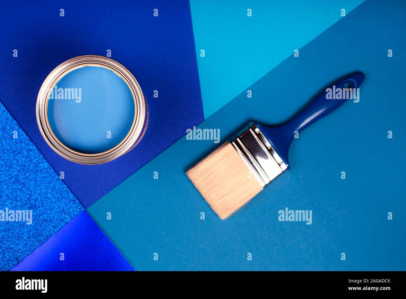 Brush on open can of blue paint on blue background. Color of the year ...