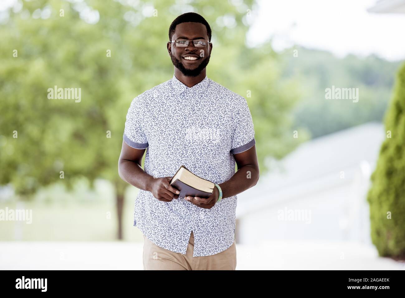 Shallow focus shot of a male standing while holding the bible and ...