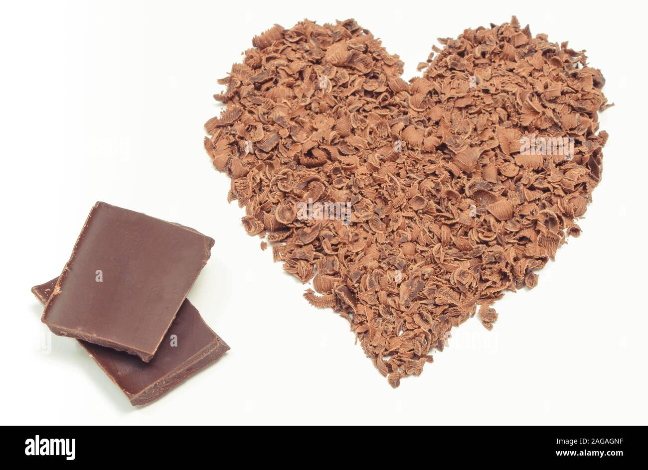 Grated chocolate in shape of heart and portion of chocolate on white ...