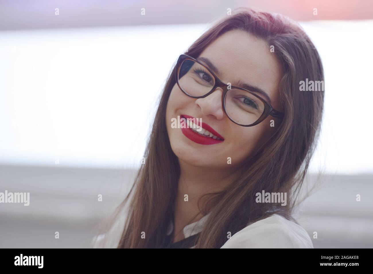 Beautiful female student wearing glasses at university campus interior ...