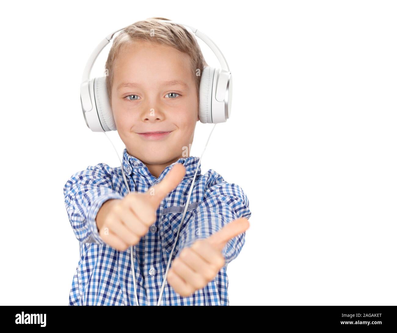 Young boy listening to music with headphones and making thumbs up ...