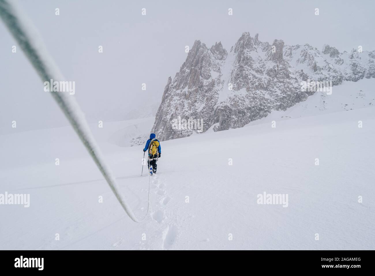 An alpinist walking on a glacier using rope. Detail shot of climber ...