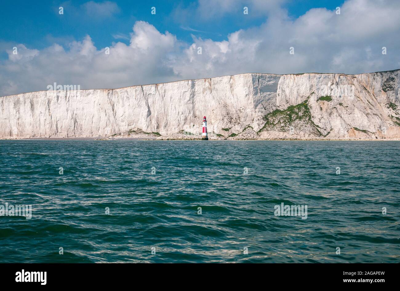 White cliffs of Beachy Head and the lighthouse viewed from a boat ...