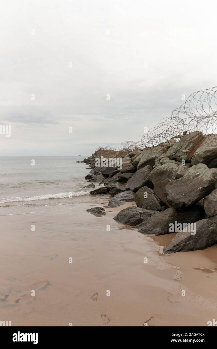 A close up view of the side of the harbour with large rocks and barded ...