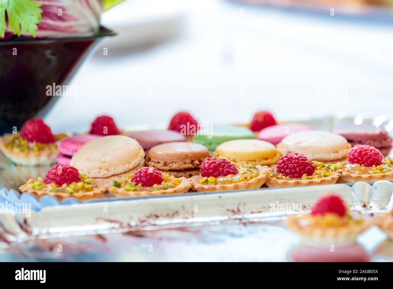 Closeup shot of delicious macaroons and raspberry dessert with a ...