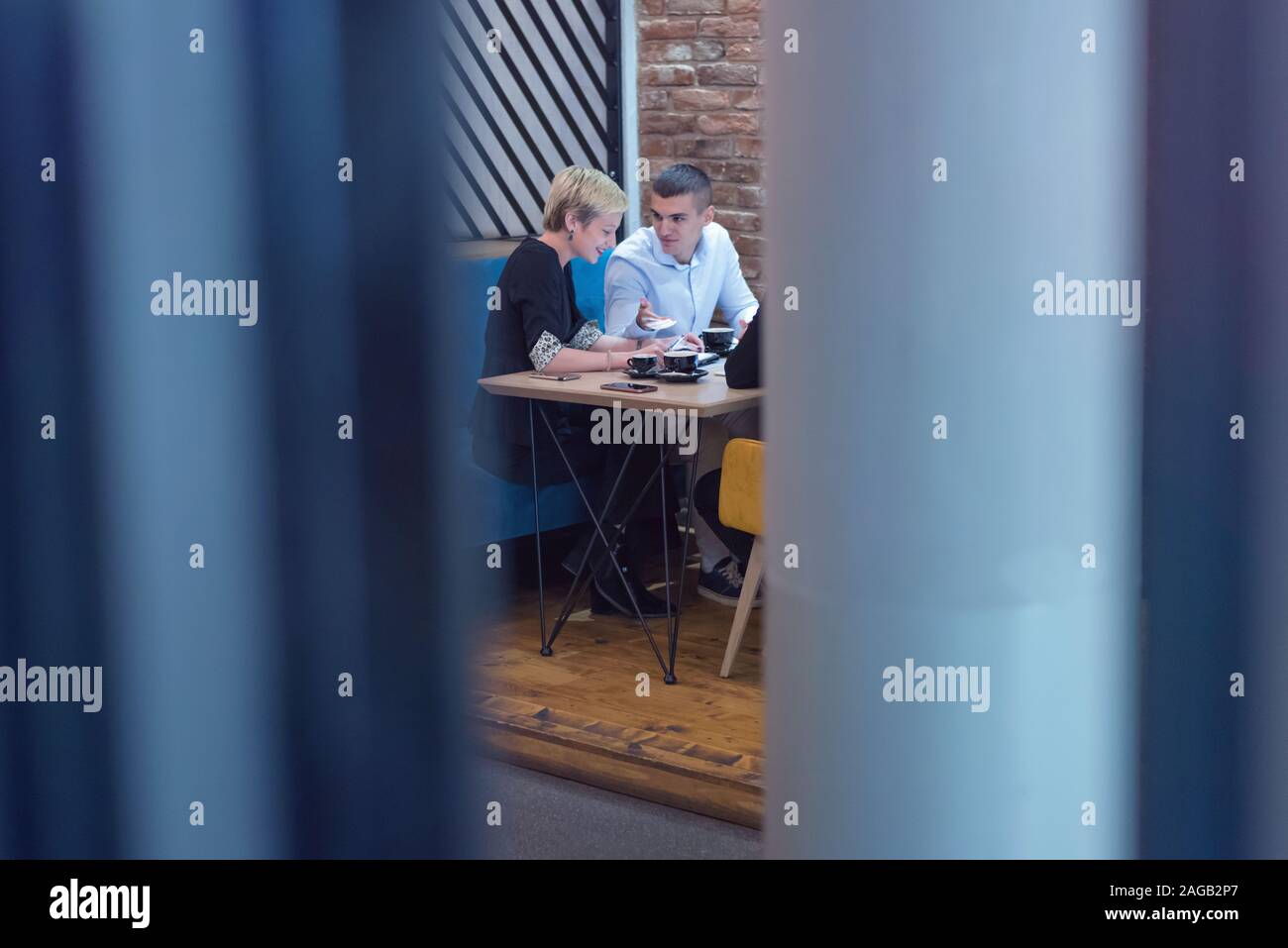 Two young male and female multiracial business people working connected ...