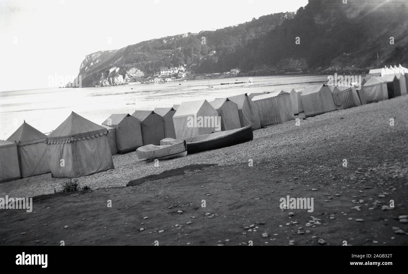1930s, historical, a row of canvas huts on a stoney beach, England, UK ...