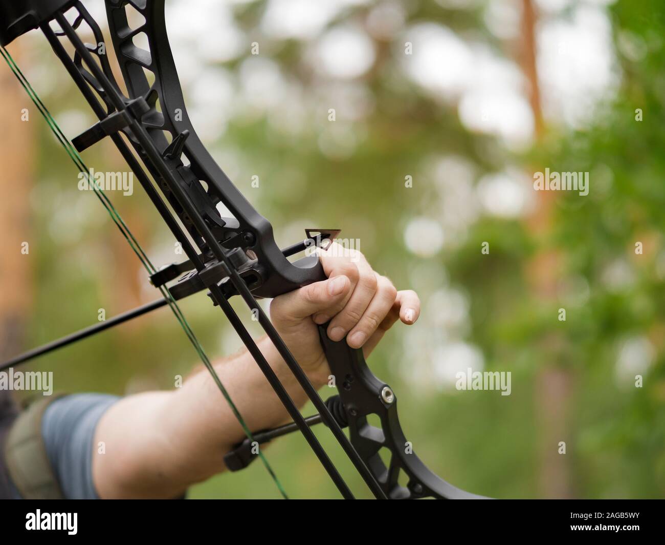Man aims with a bow. Focus on the arrowhead. Bow hunting concept Stock ...