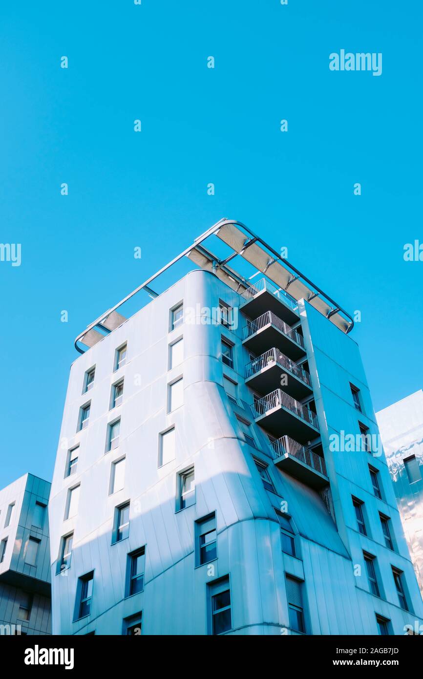 Vertical low angle shot of a geometrical buildings under the clear blue ...