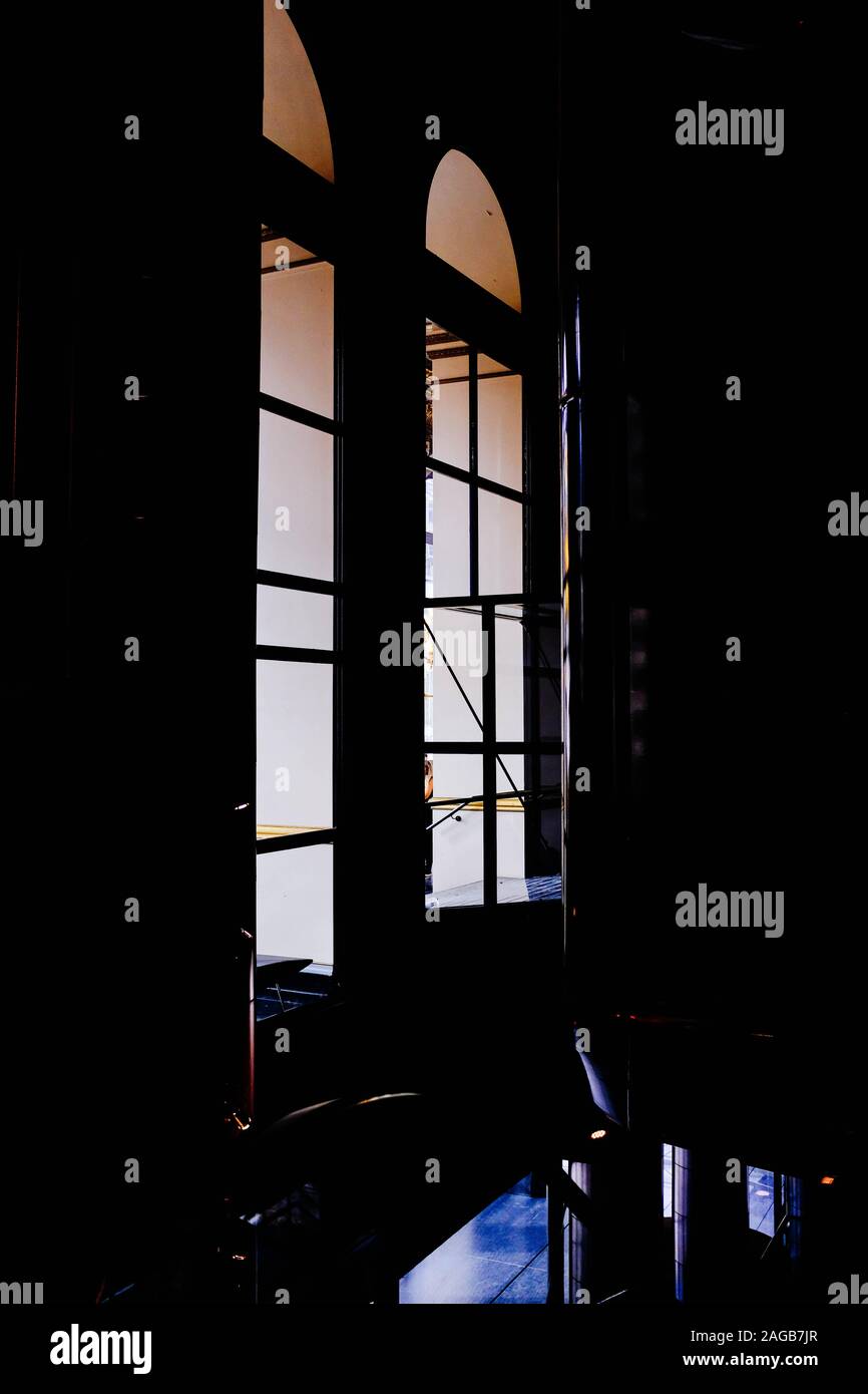 Vertical shot of the light coming in through the windows to a dark room ...
