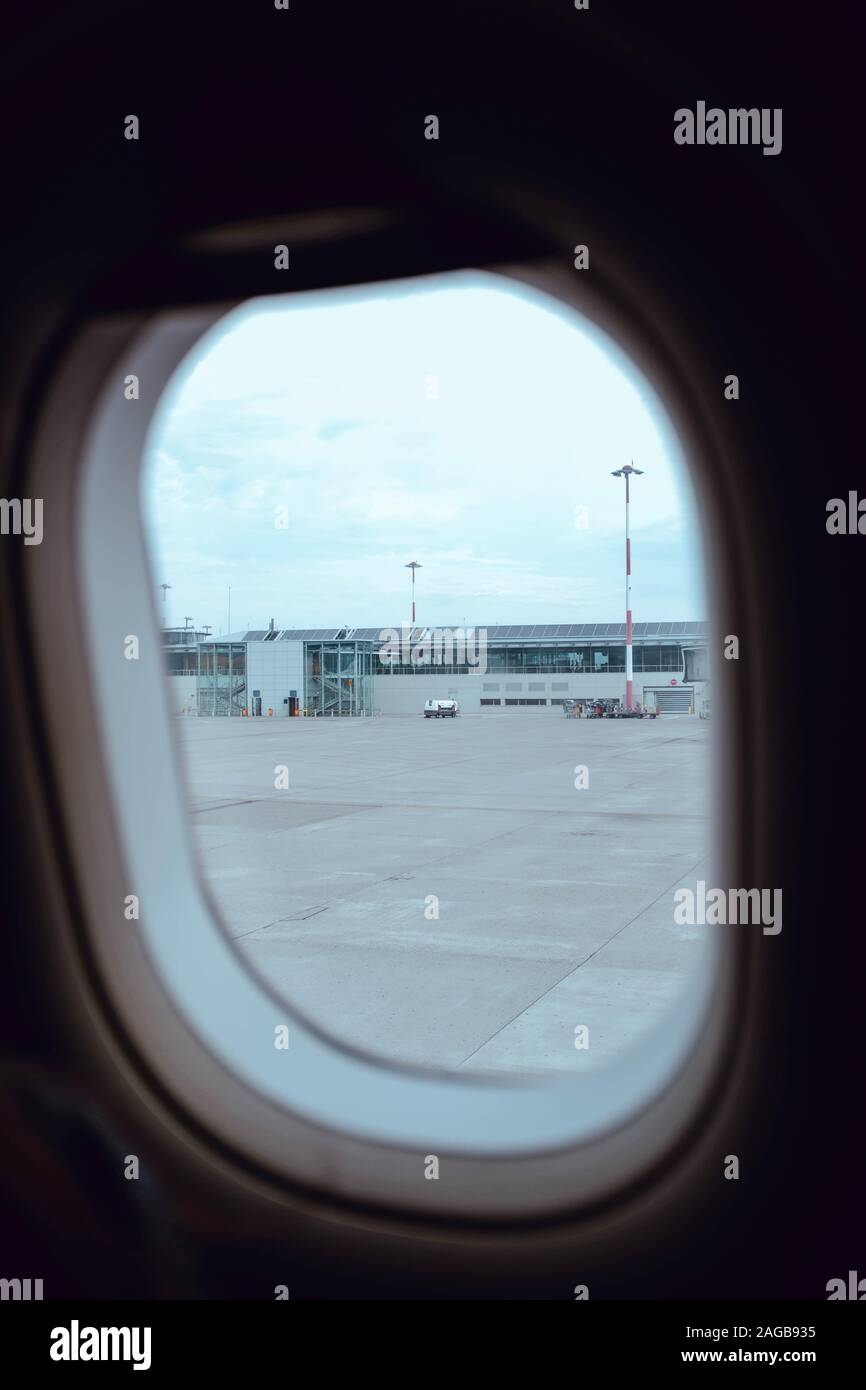 Vertical shot of an airplane window showing the world outside of the ...
