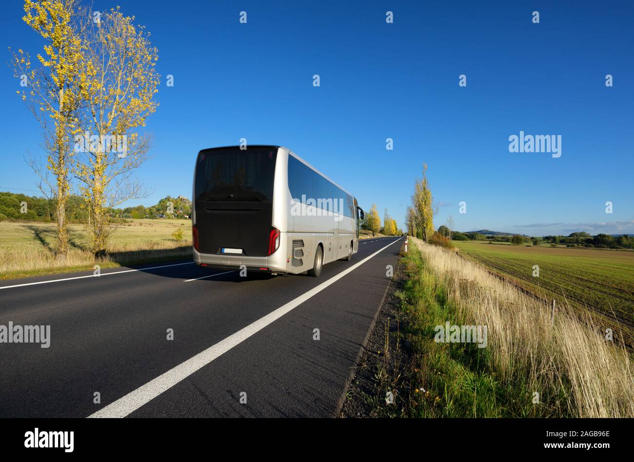 Bus driving on asphalt road in autumn rural landscape Stock Photo - Alamy