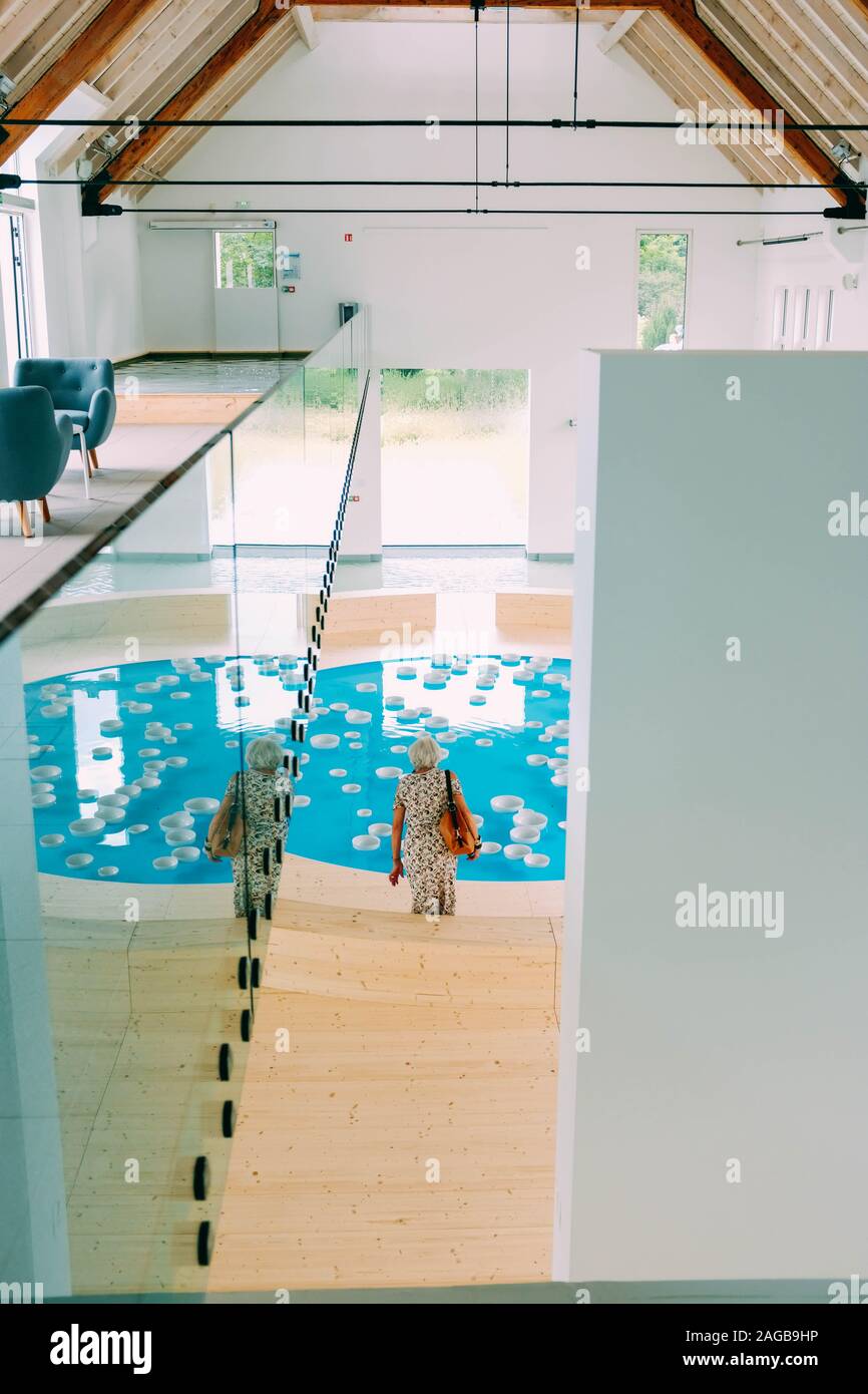 Female walking in a cool pool room with comfortable minimalistic ...