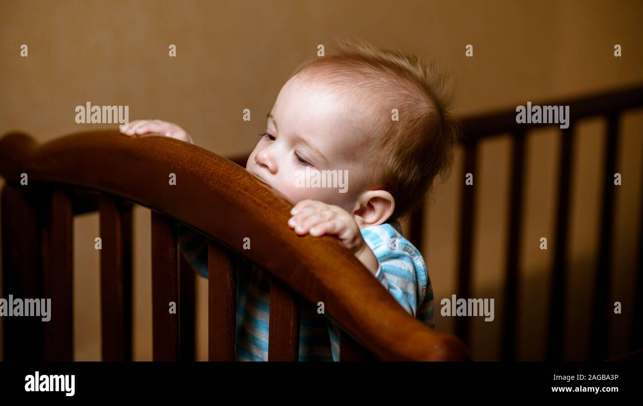 little boy chewing on her bed at home Stock Photo - Alamy