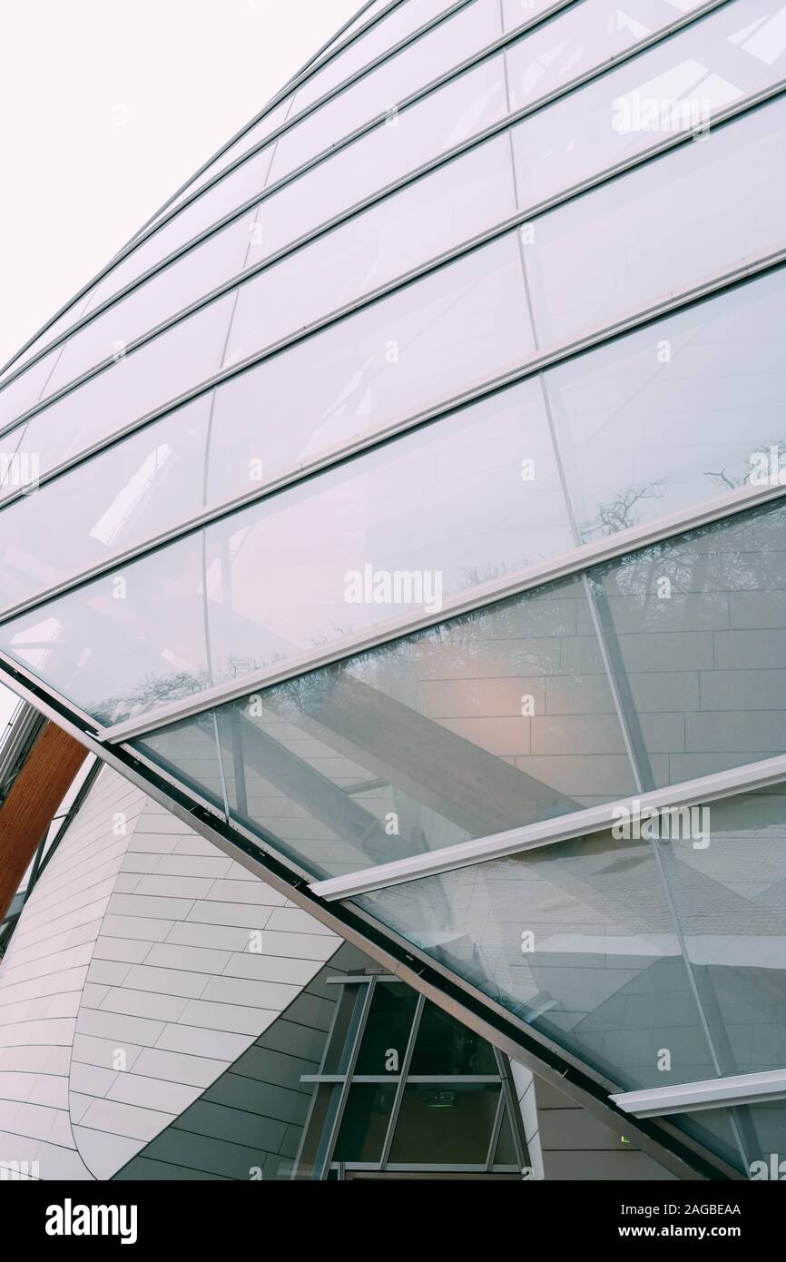 Closeup look of a modern building with white glass windows under a grey ...