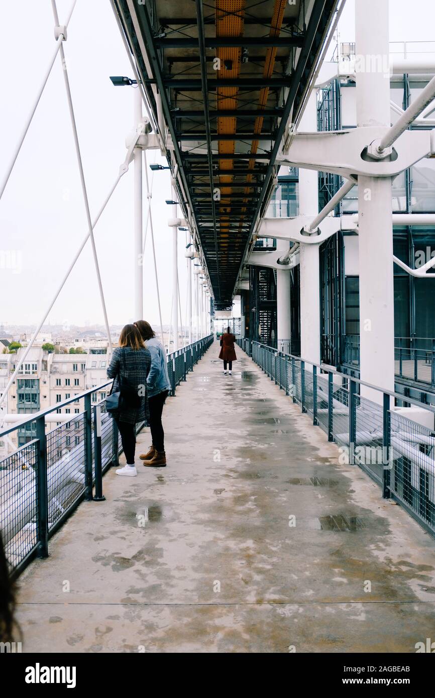 View of a bridge with people walking through it surrounded by modern ...