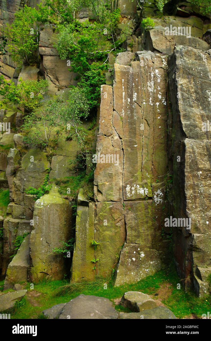 Abandoned worked gritstone faces in sunlight at Bole Hill Quarry near ...