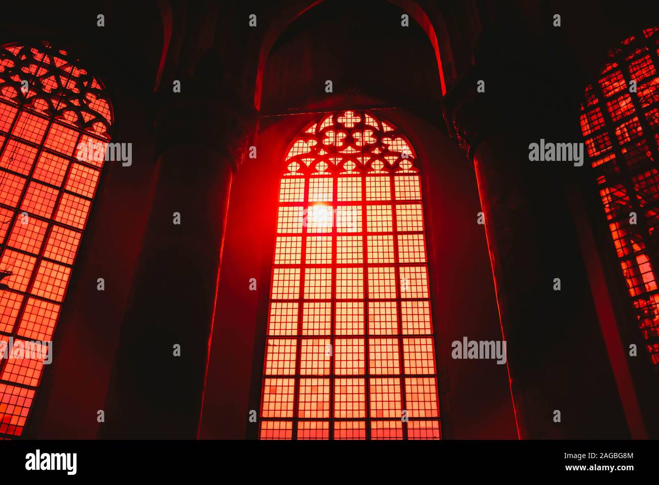 Low angle shot of the red light of sun shining through the arch shaped ...