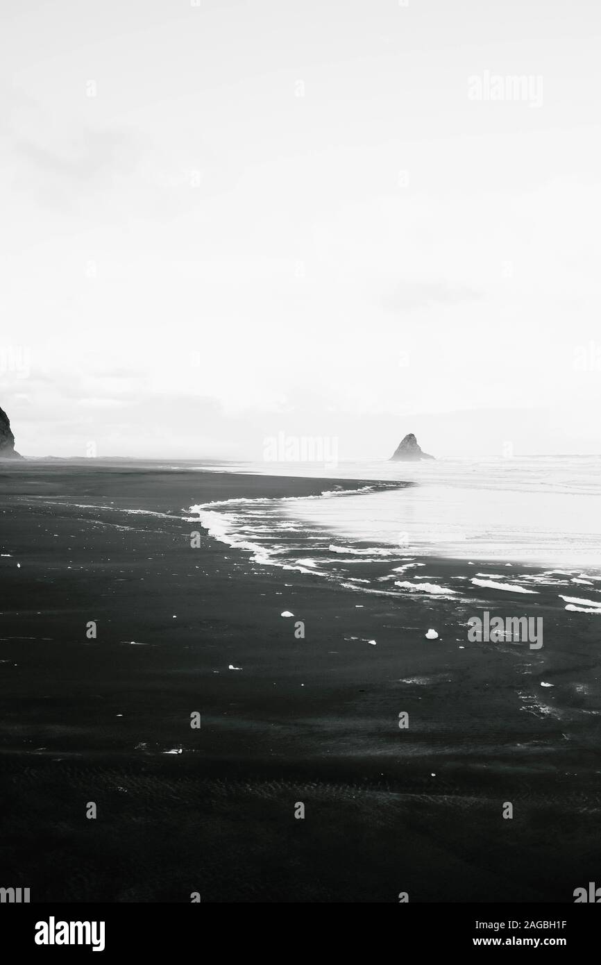 Vertical grey scale shot of the ocean waves under the bright sky Stock ...