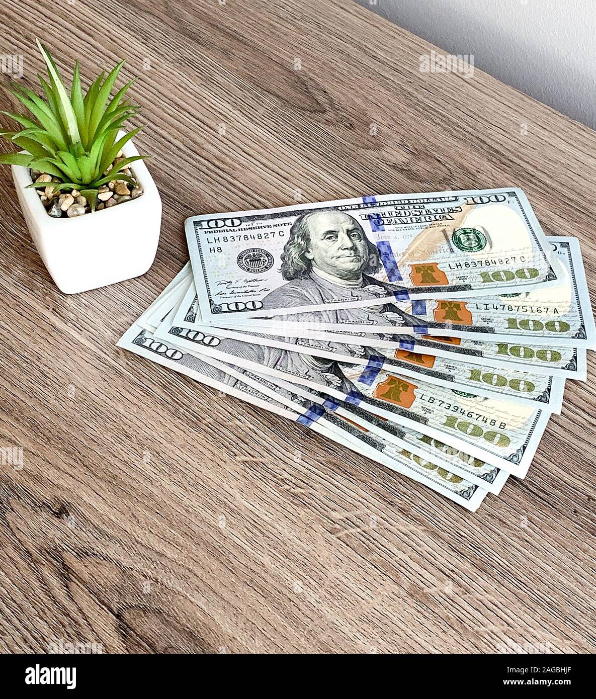 Stack of one hundred dollars bills on wooden desk Stock Photo - Alamy