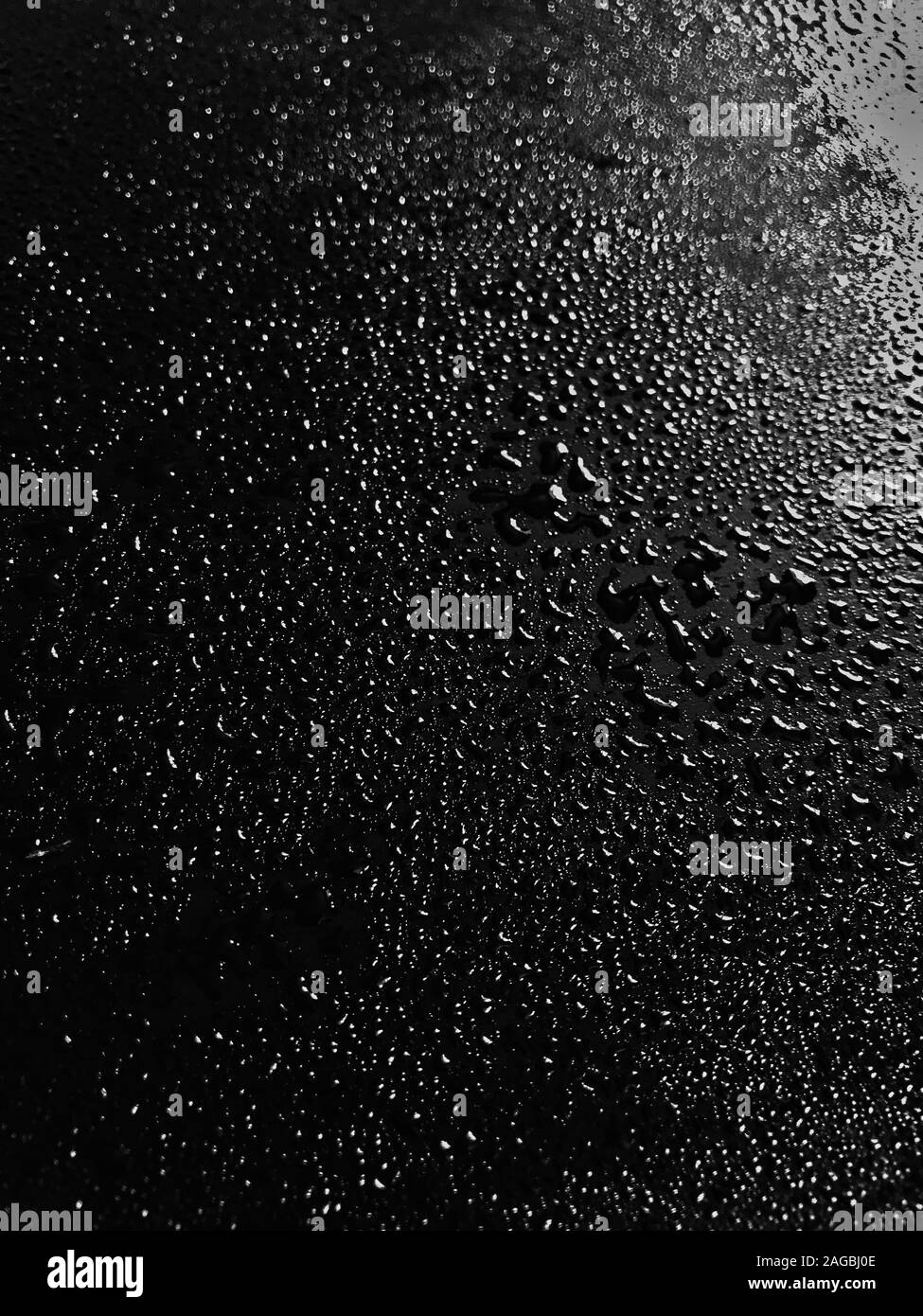 Vertical grey scale shot of water drops on a black table Stock Photo ...