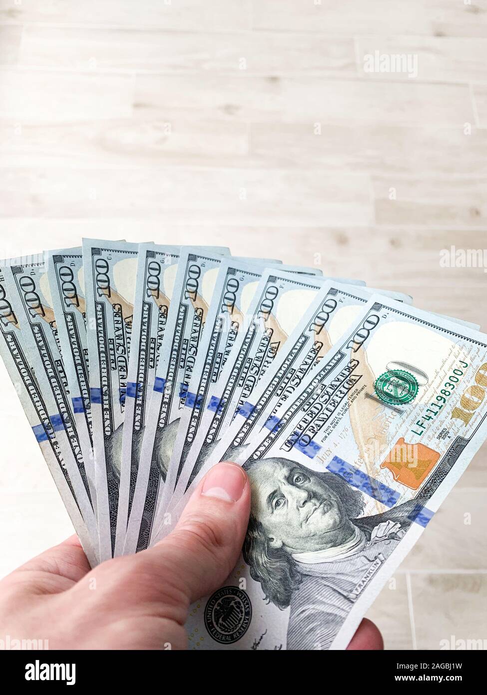 Hand holding banknote bundle of US dollar in hand Stock Photo - Alamy