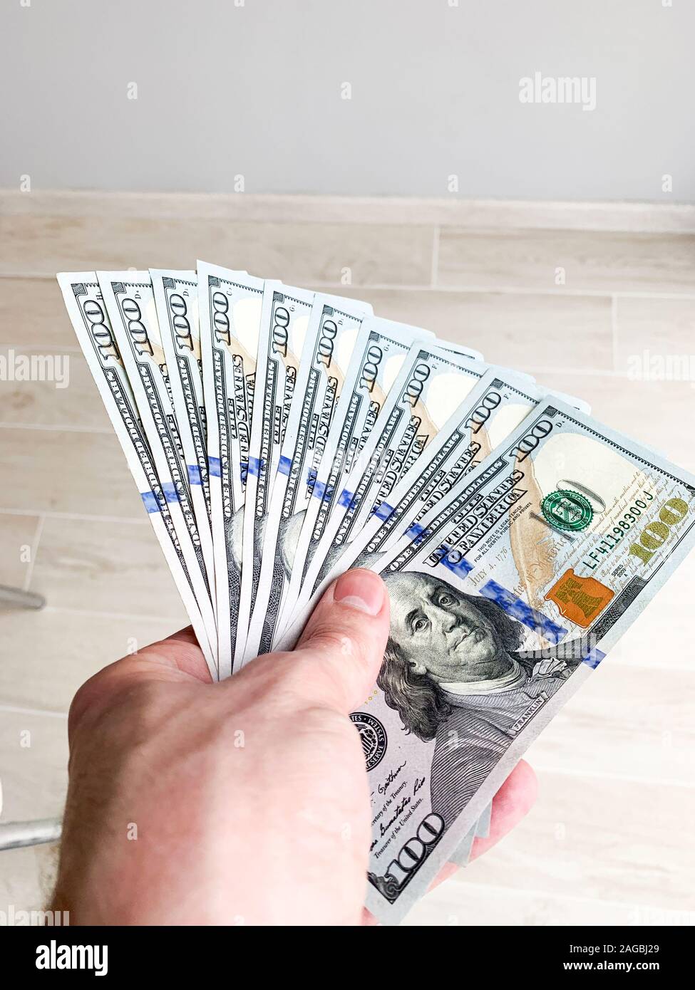 Hand holding banknote bundle of US dollar in hand Stock Photo - Alamy