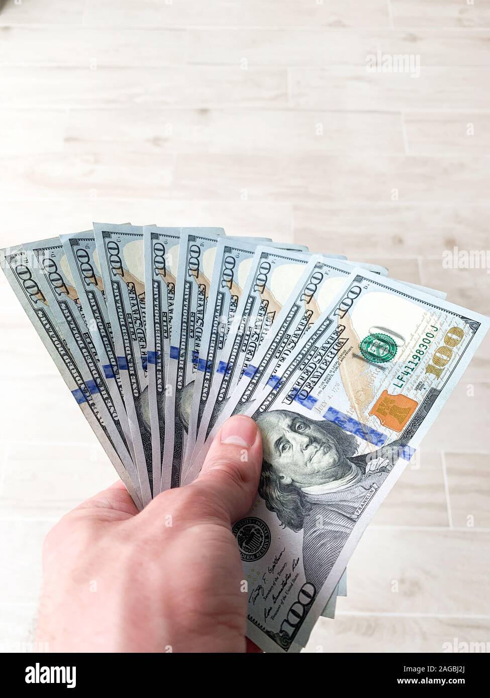 Hand holding banknote bundle of US dollar in hand Stock Photo - Alamy